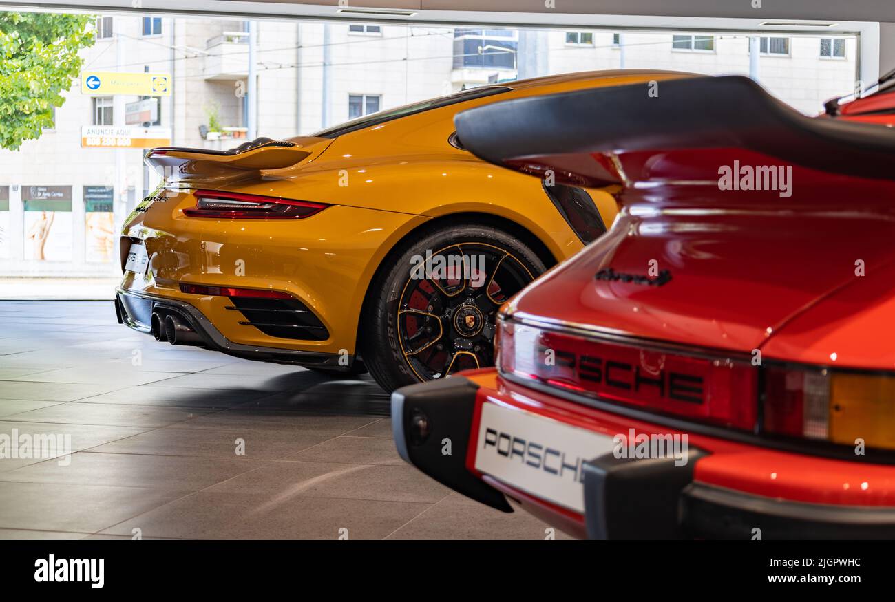A picture of a red Porsche 911 Carrera 3.0 next to an orange Porsche ...