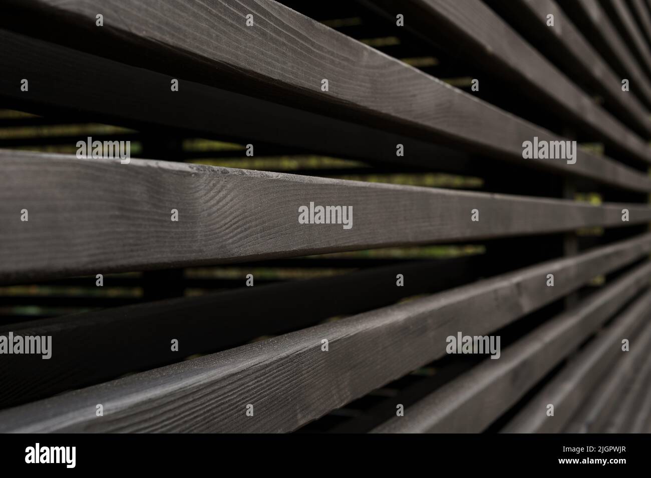 Side view of a wall of black horizontal wooden bars. The beauty of ...