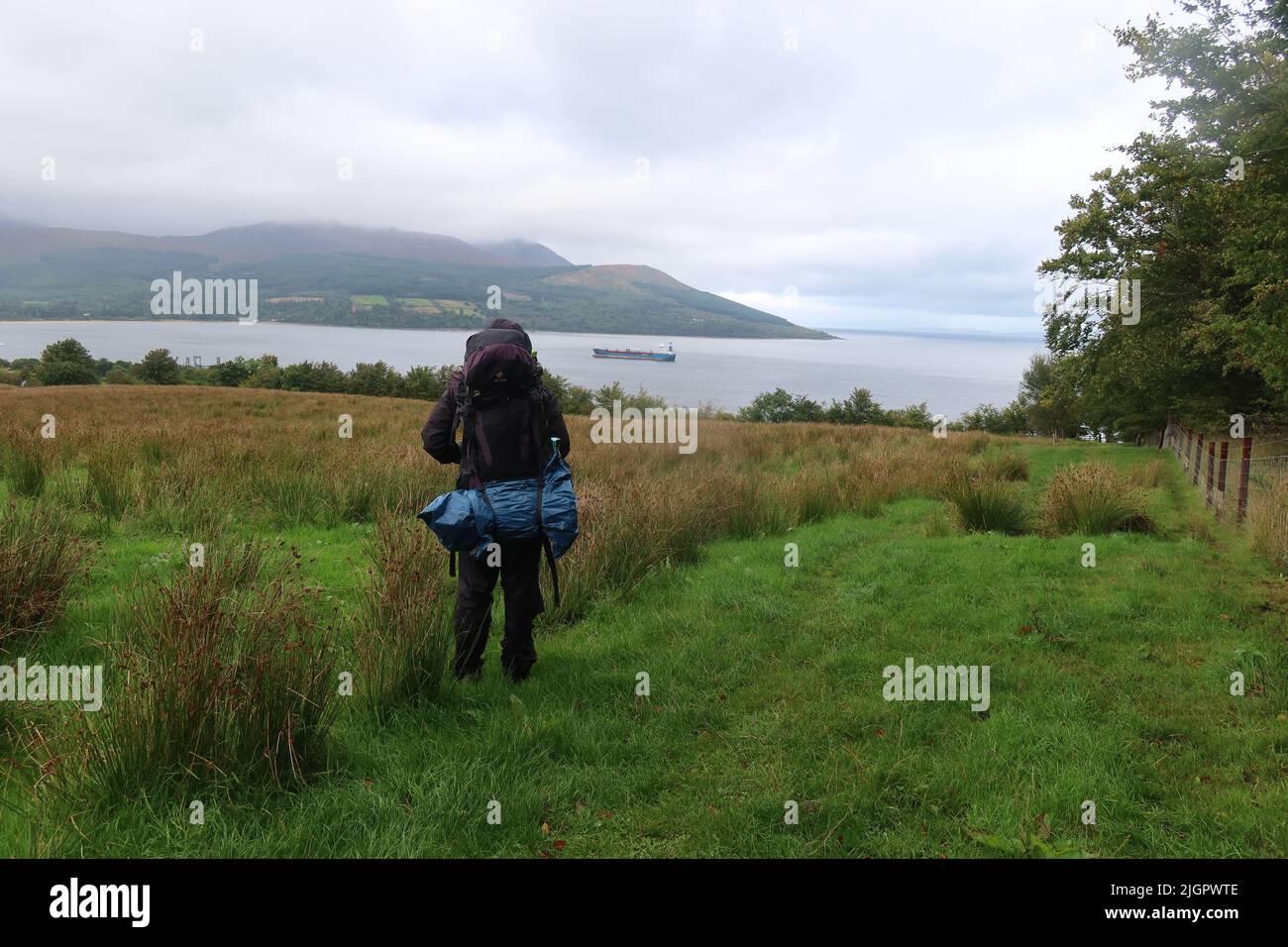 Solo Backpacker hiking with a big backpack. Arran Coastal Way. Isle of ...