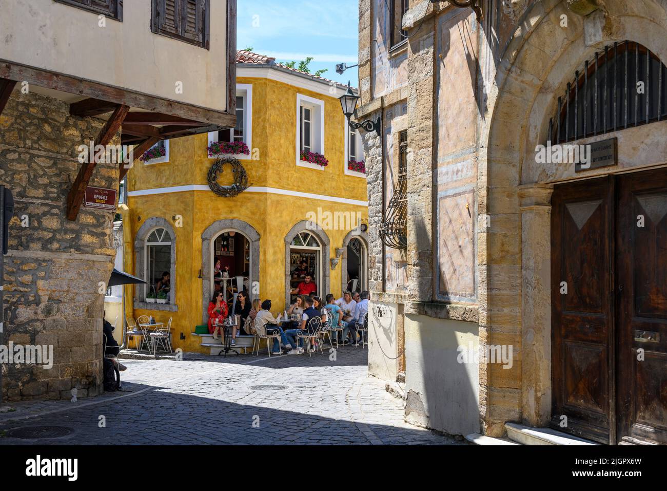 Customers chatting at a coffee bar in the center of Xanthi's old town ...