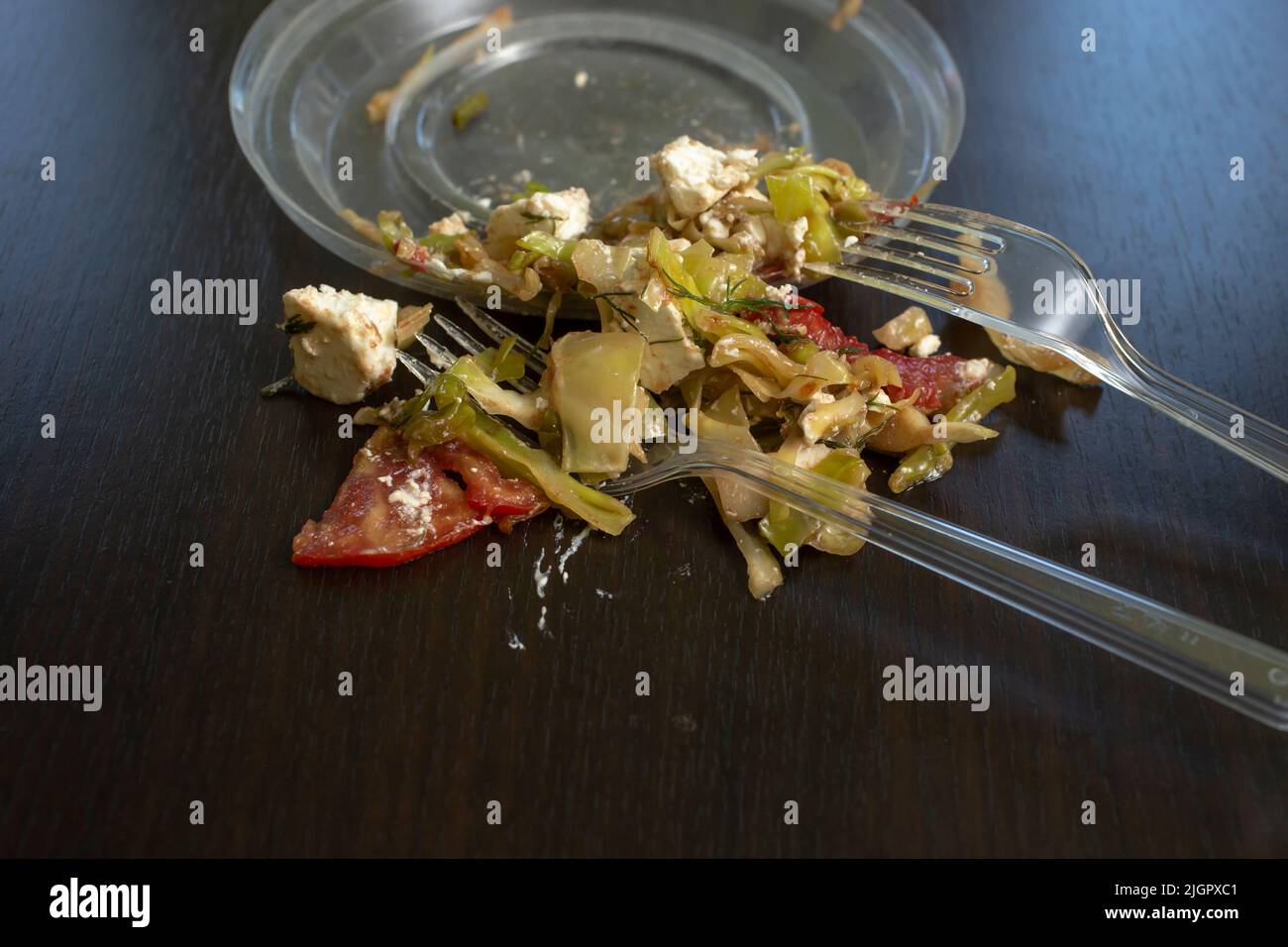 Bad decayed salad with plastic cutlery on black background Stock Photo ...