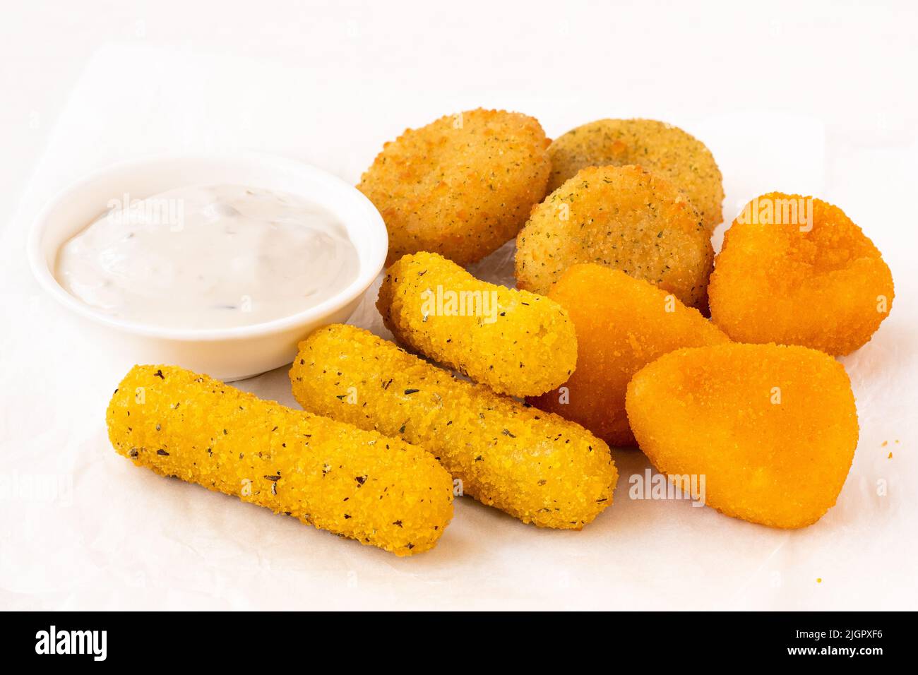 Selection of breaded fried cheese on a white baking paper with white ...