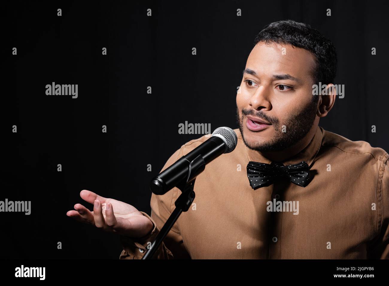 confused eastern stand up comedian telling jokes into microphone on ...