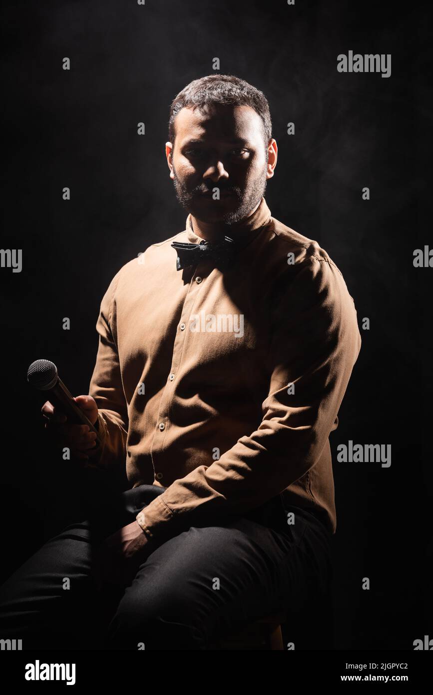 indian stand up comedian holding microphone and sitting isolated on ...