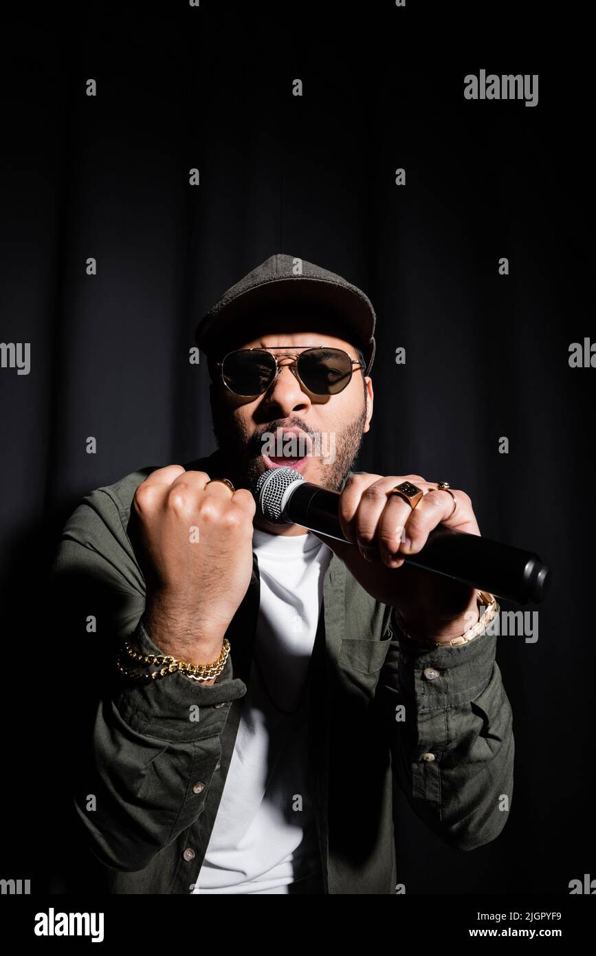 emotional middle east hip hop performer with clenched fist singing in ...