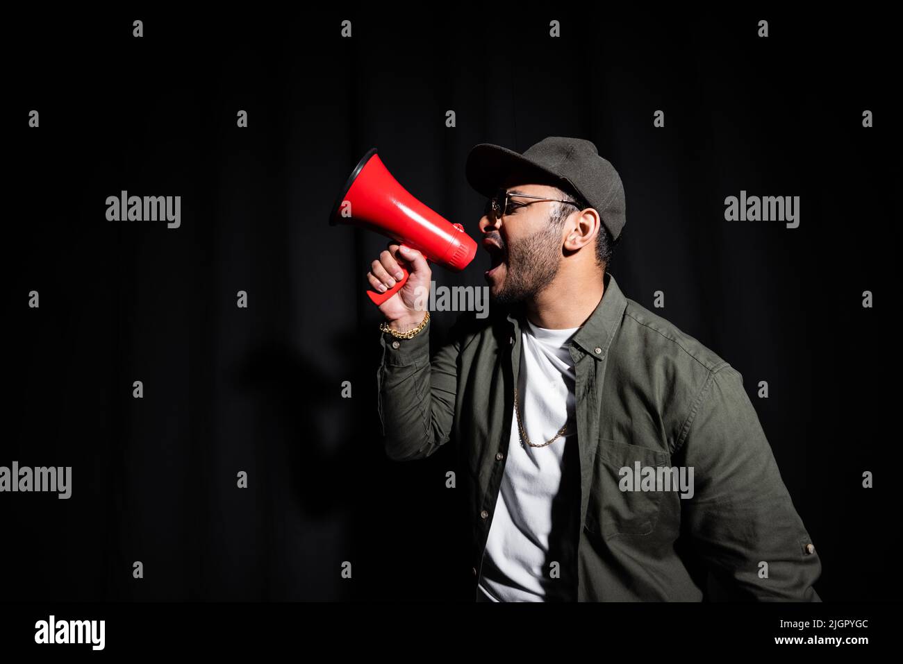 side view of emotional middle east hip hop performer in sunglasses and ...