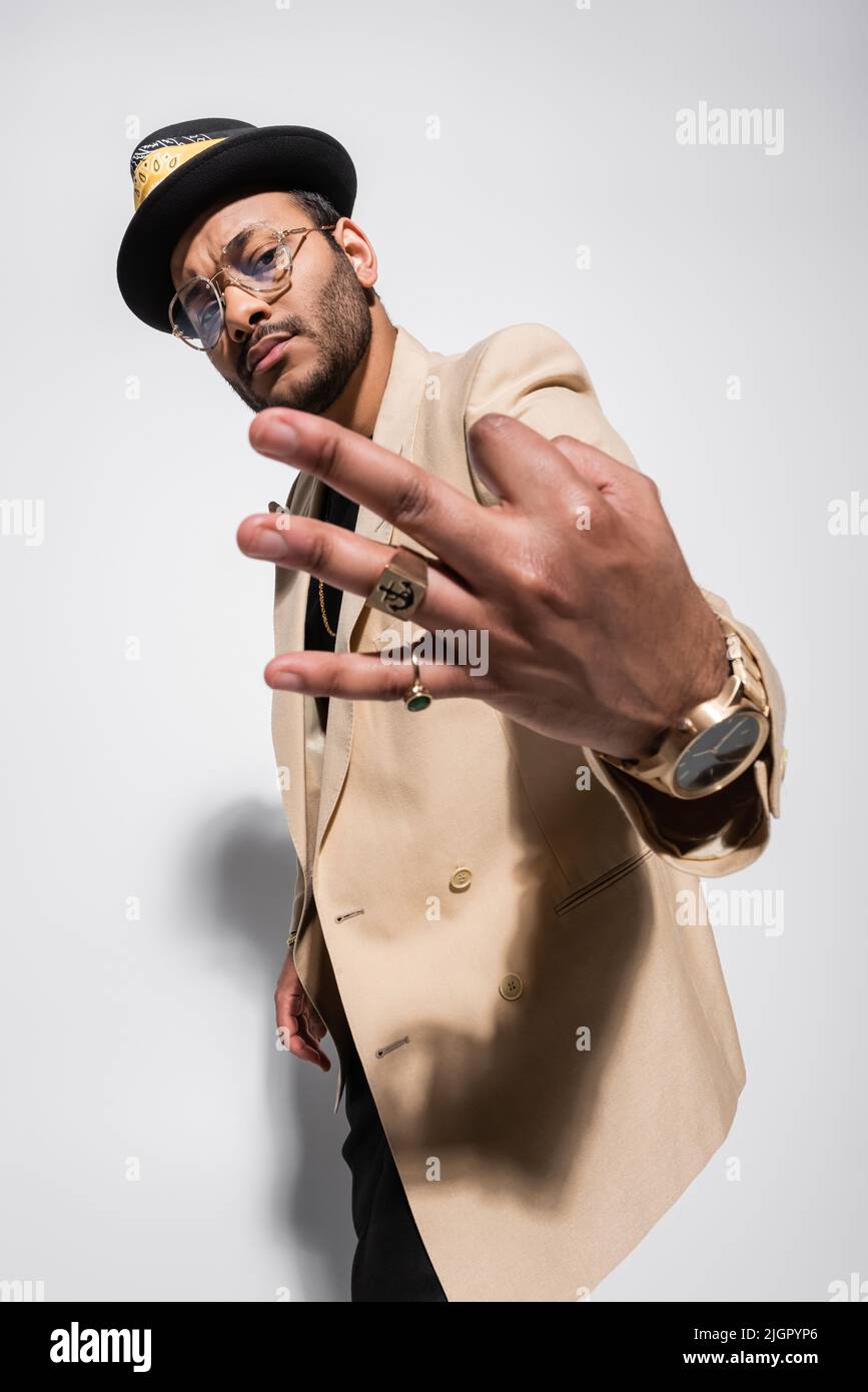 bearded eastern hip hop singer in fedora hat and eyeglasses showing ...