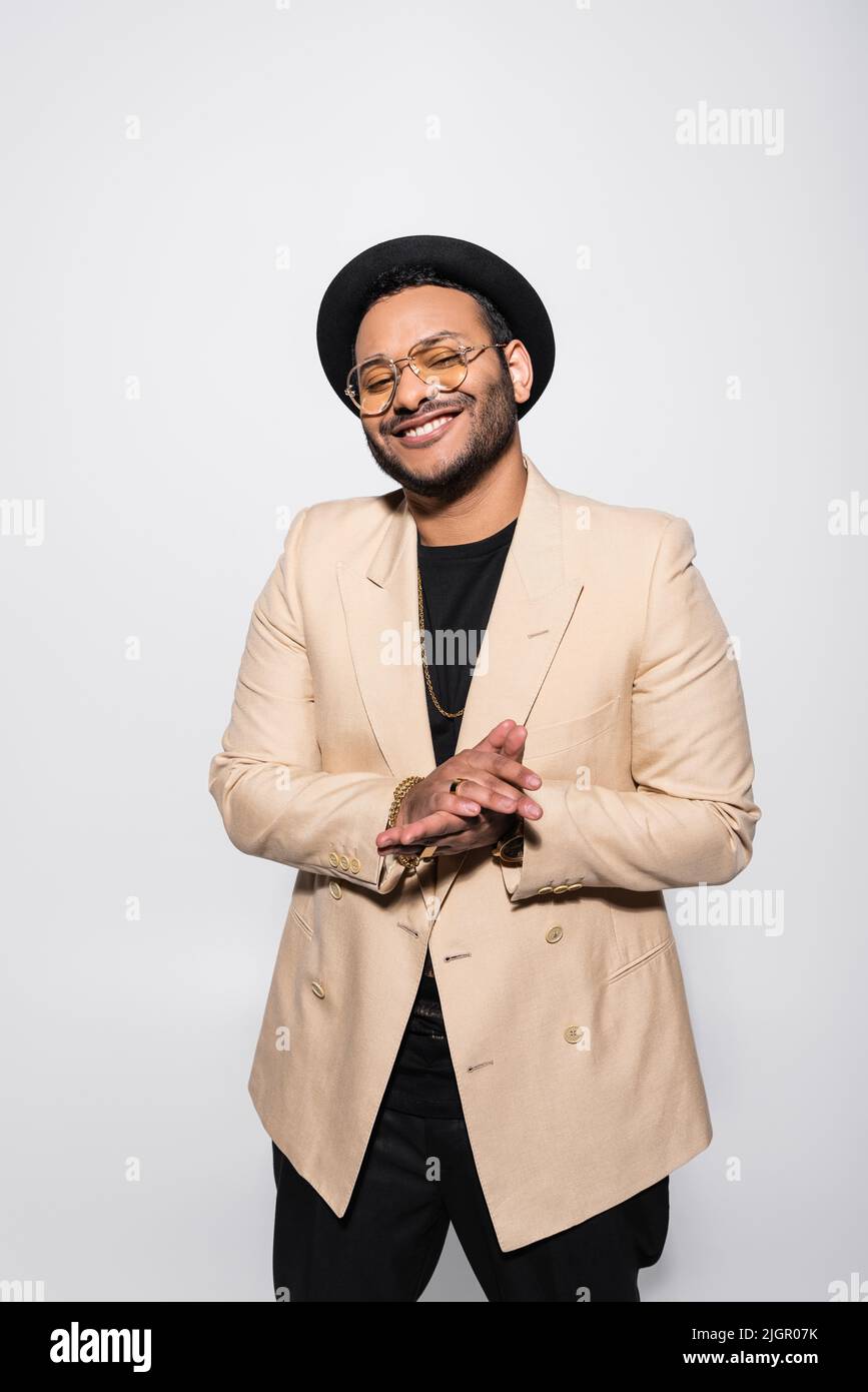 happy indian hip hop performer in fedora hat and stylish eyeglasses ...