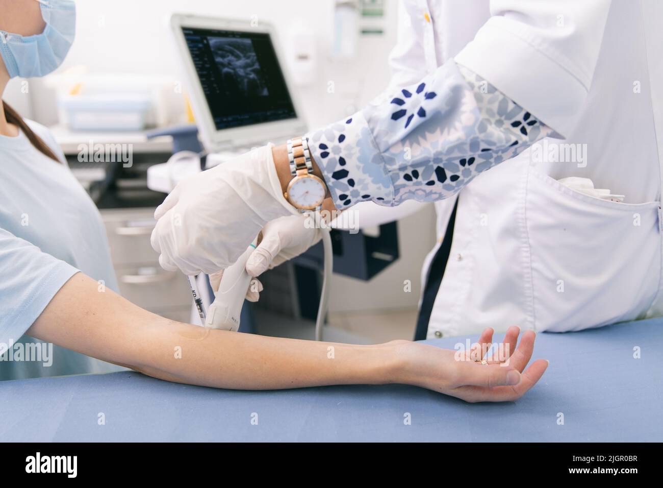 Doctor doing the ultrasound on the hand close up. Doctor demonstrates ...