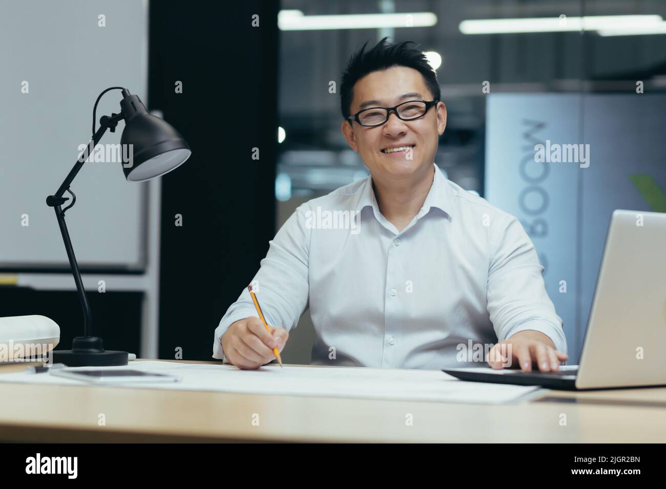 Portrait of Asian designer, creative work, man looking at camera and ...