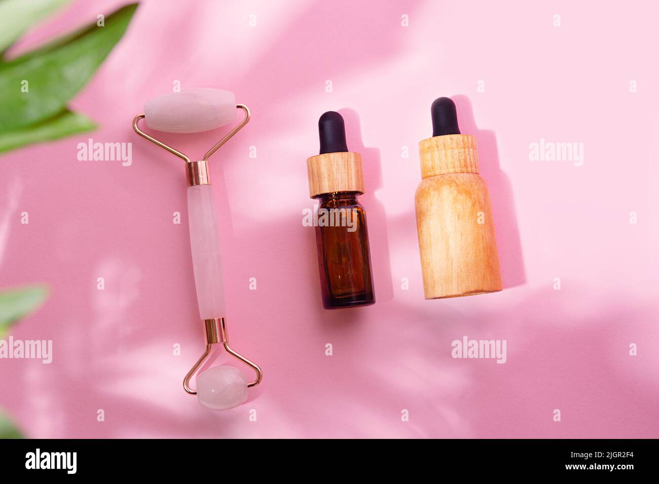 Facial roller from pink quartz and two oil bottles,makeup concept Stock ...