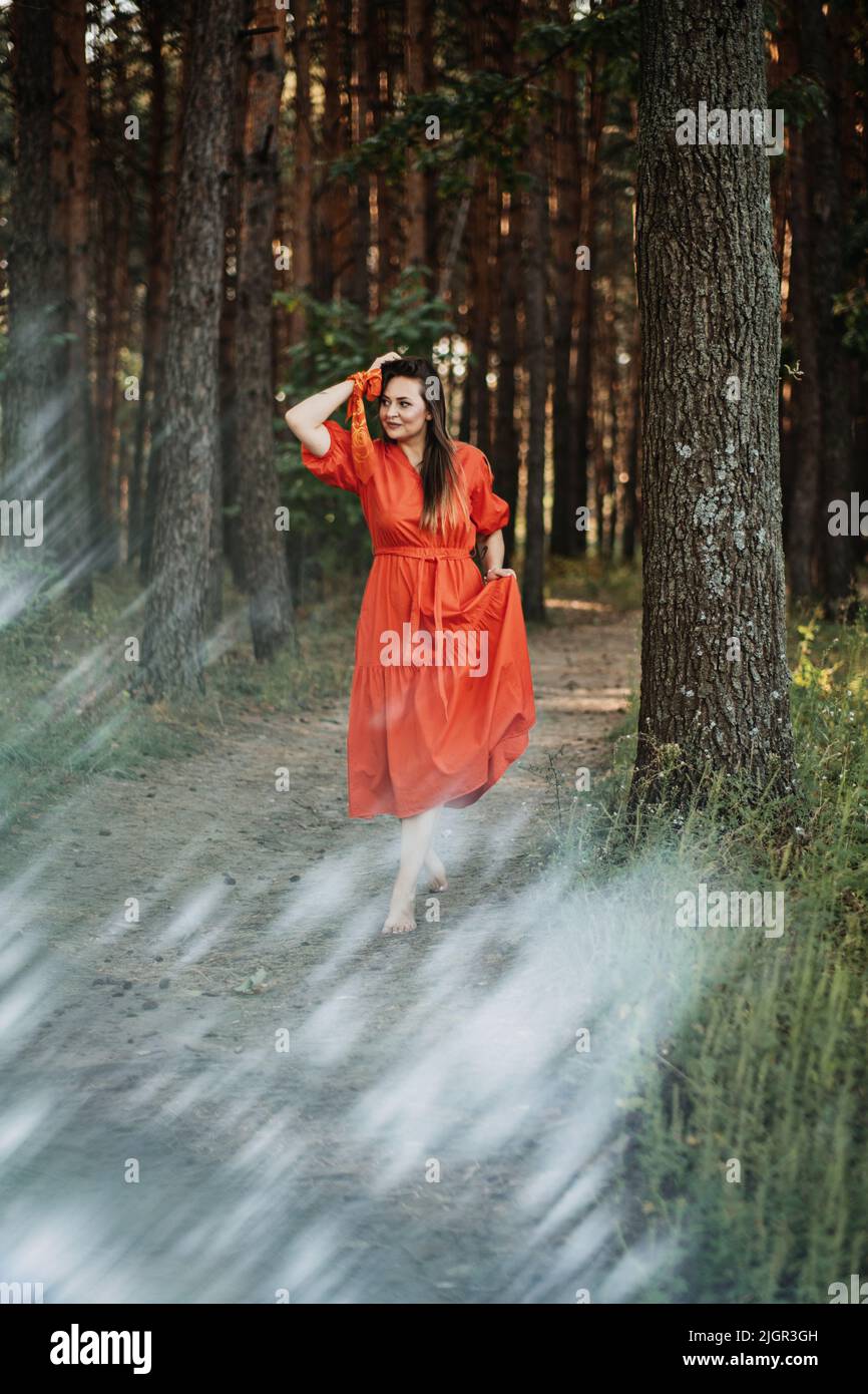 Peace of mind, breathing fresh air. Alone woman in red dress enjoys the ...