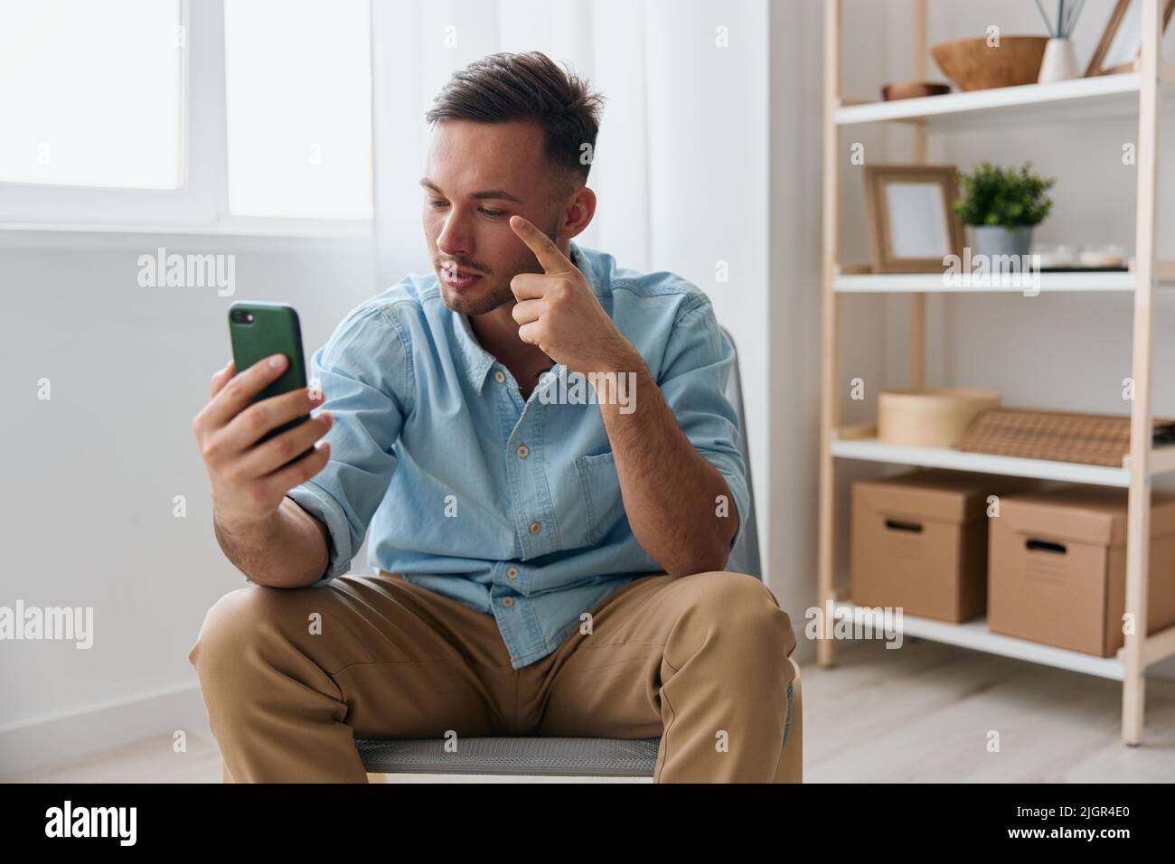 Cheerful smiling communicative guy talk with family using phone video ...