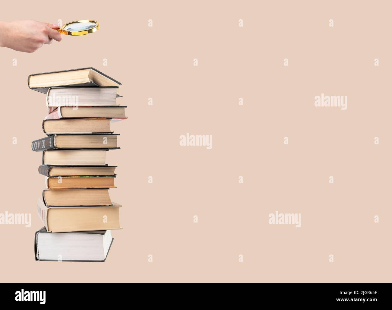 Hand holding lens over book hi-res stock photography and images - Alamy