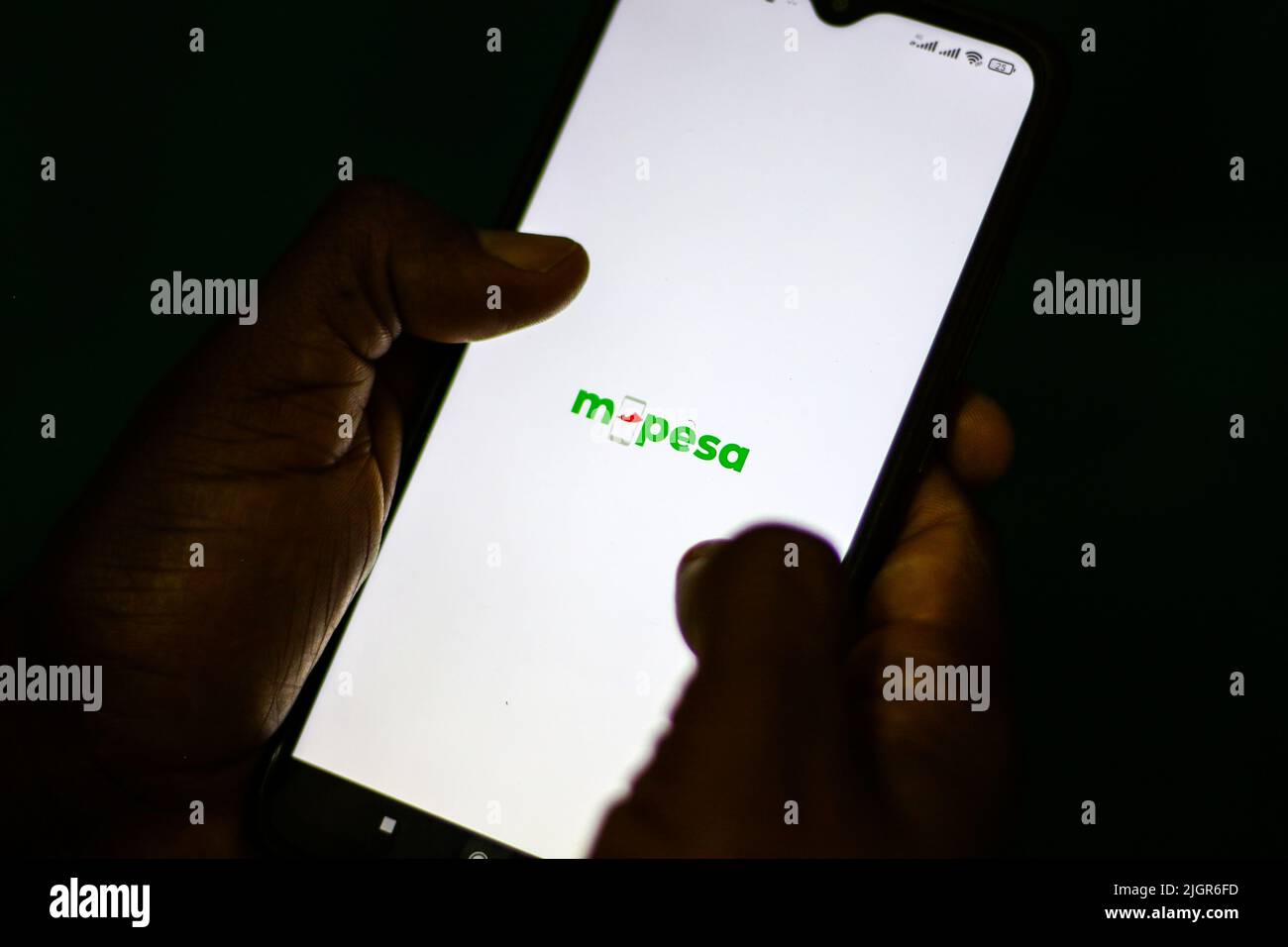 In this photo illustration, a hand holds a smartphone with the ...