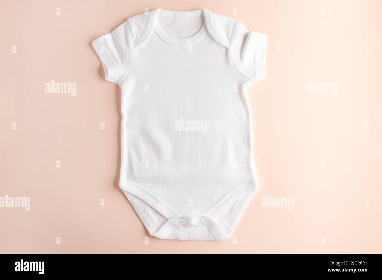 Flat lay of a cotton universal bodysuit for newborn girls on a soft ...