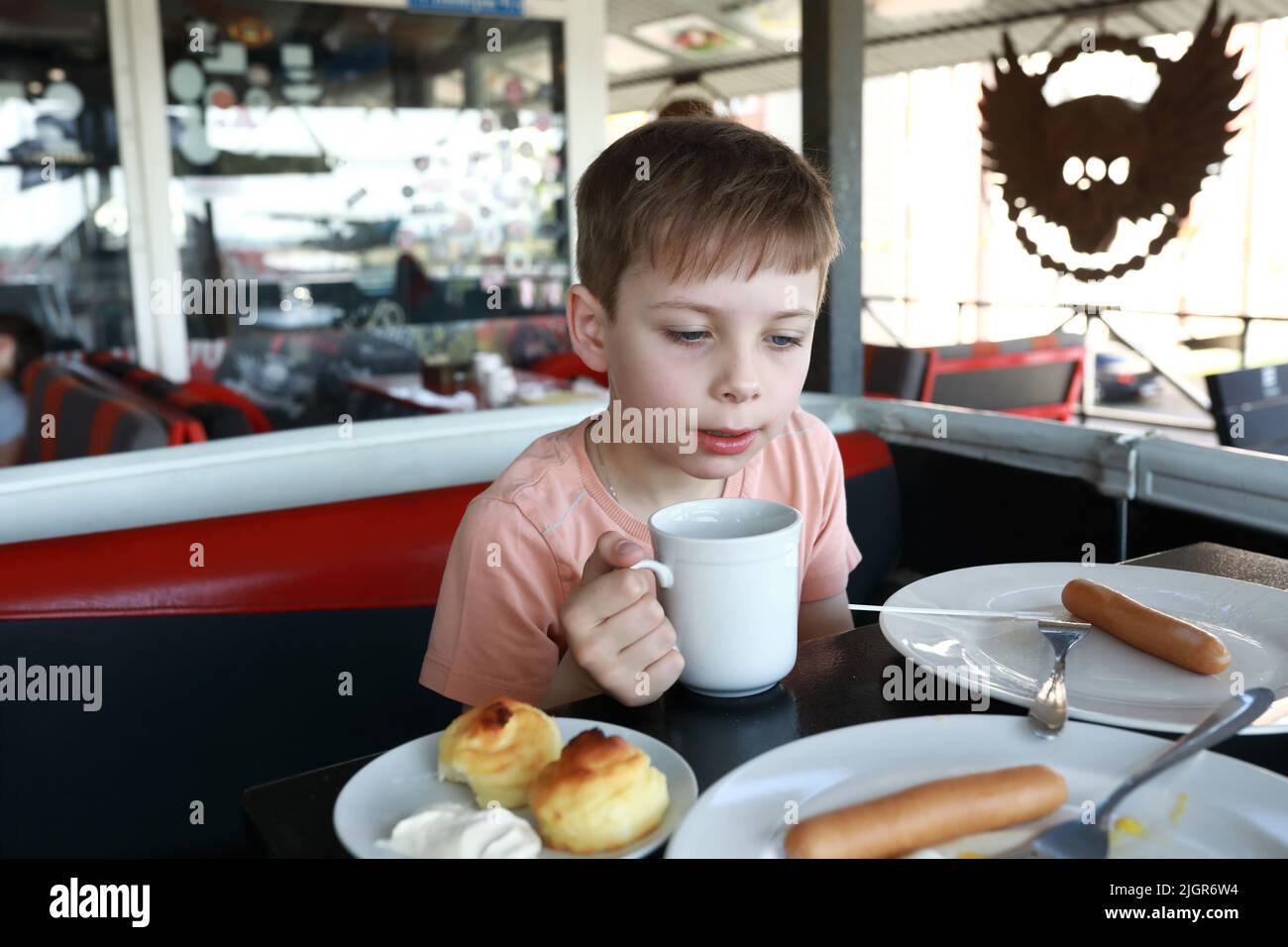 Portrait of boy drinking tea in restaurant Stock Photo - Alamy
