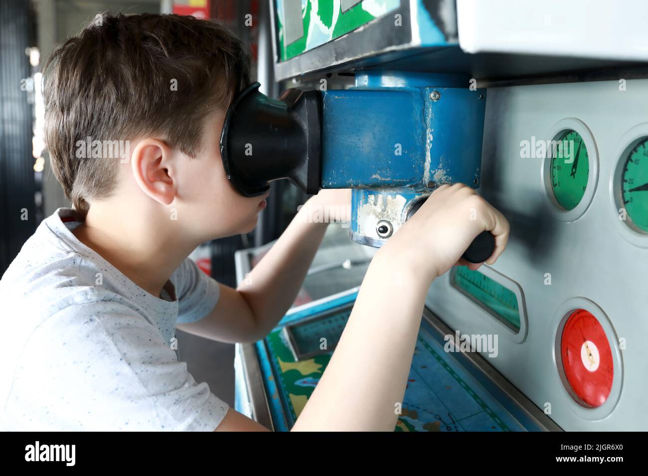 Portrait of child playing arcade on vintage apparatus Stock Photo - Alamy