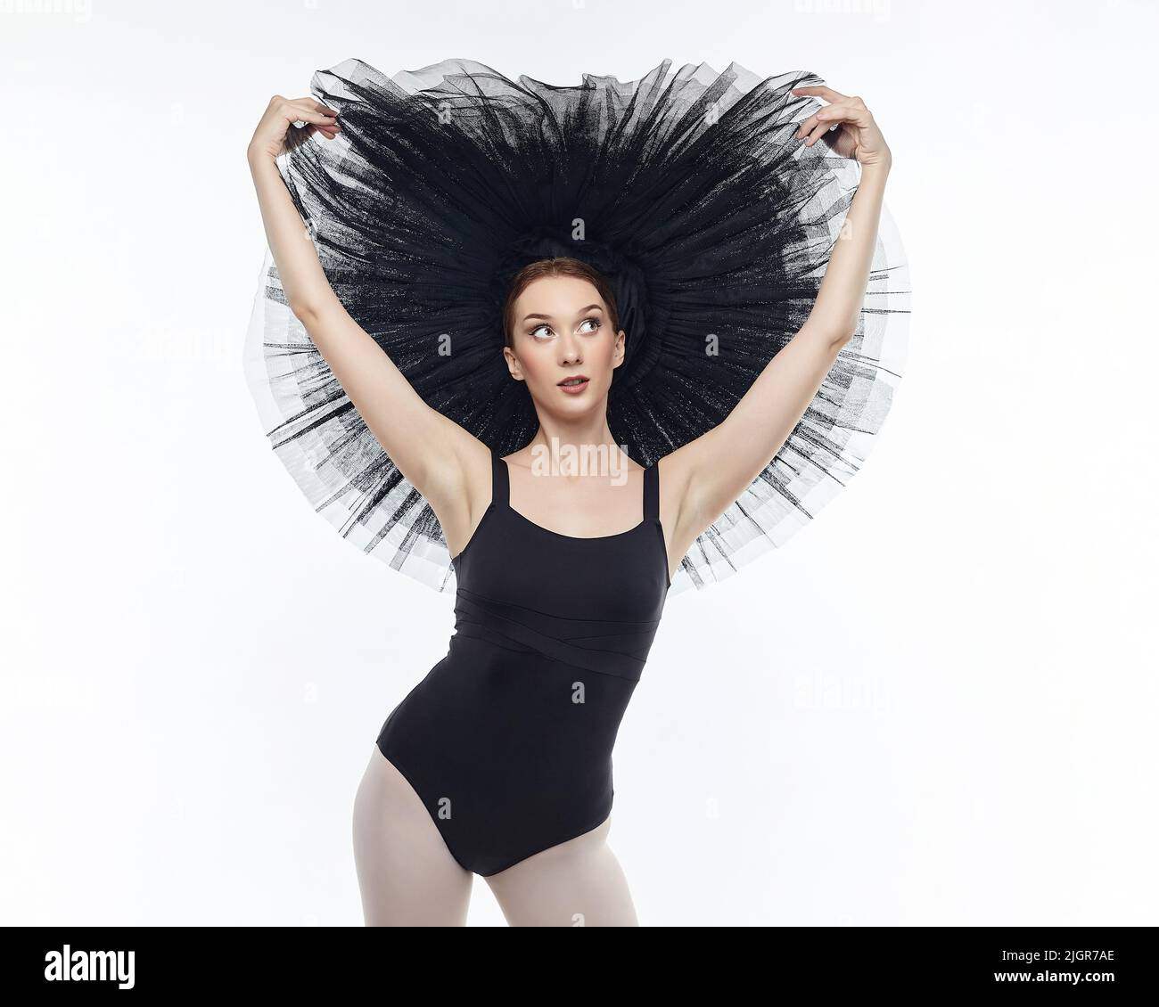 attractive ballerina put a tutu on her head. studio photo shoot on a ...