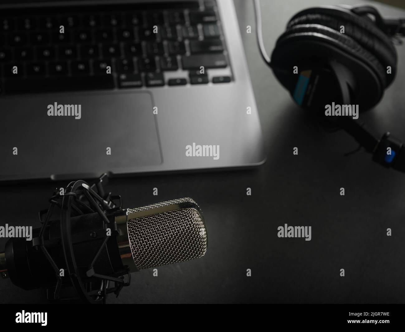 Studio microphone, laptop and studio headphones on a gray background ...