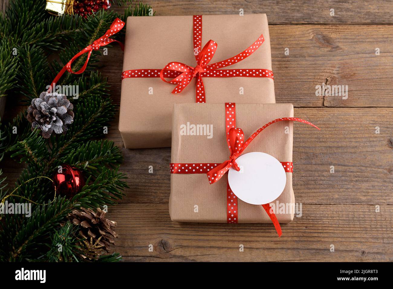 Christmas kraft gifts box with red ribbon on rustic wooden background ...