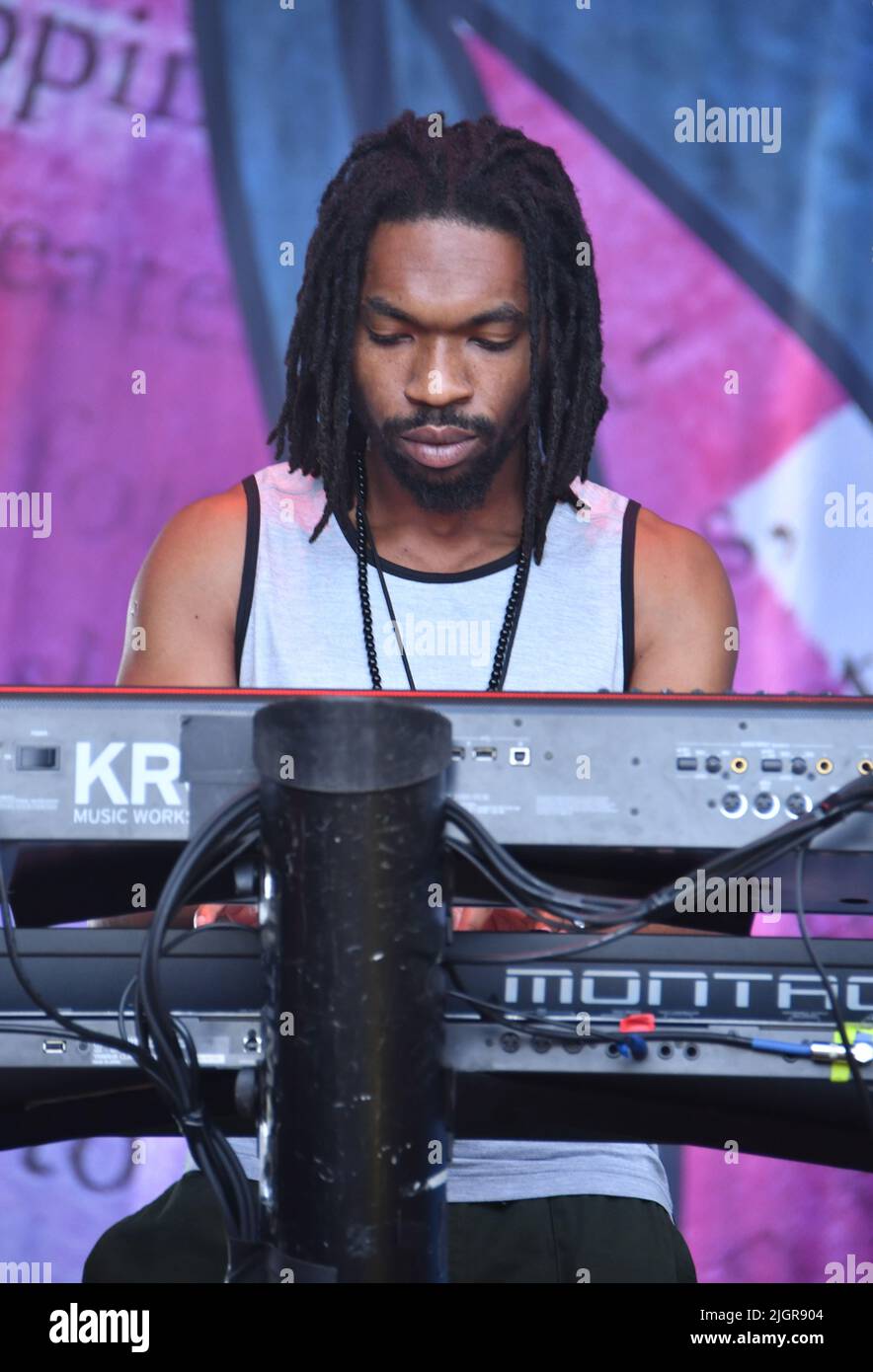 A musician performing with Stephen Marley is shown performing on stage ...