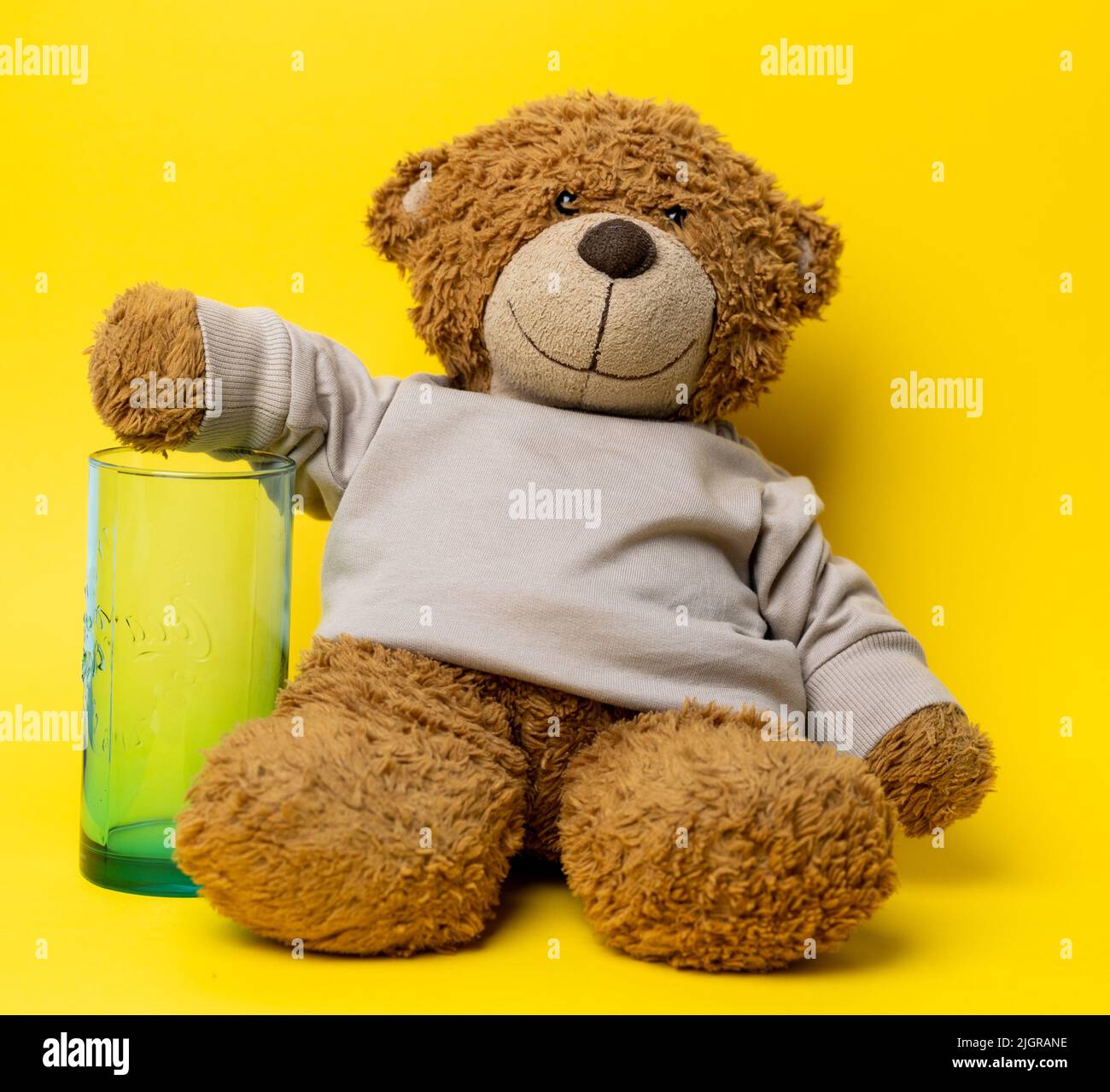 Teddy Bear holding a turquoise glass in his hand. Cute Teddy bear with ...
