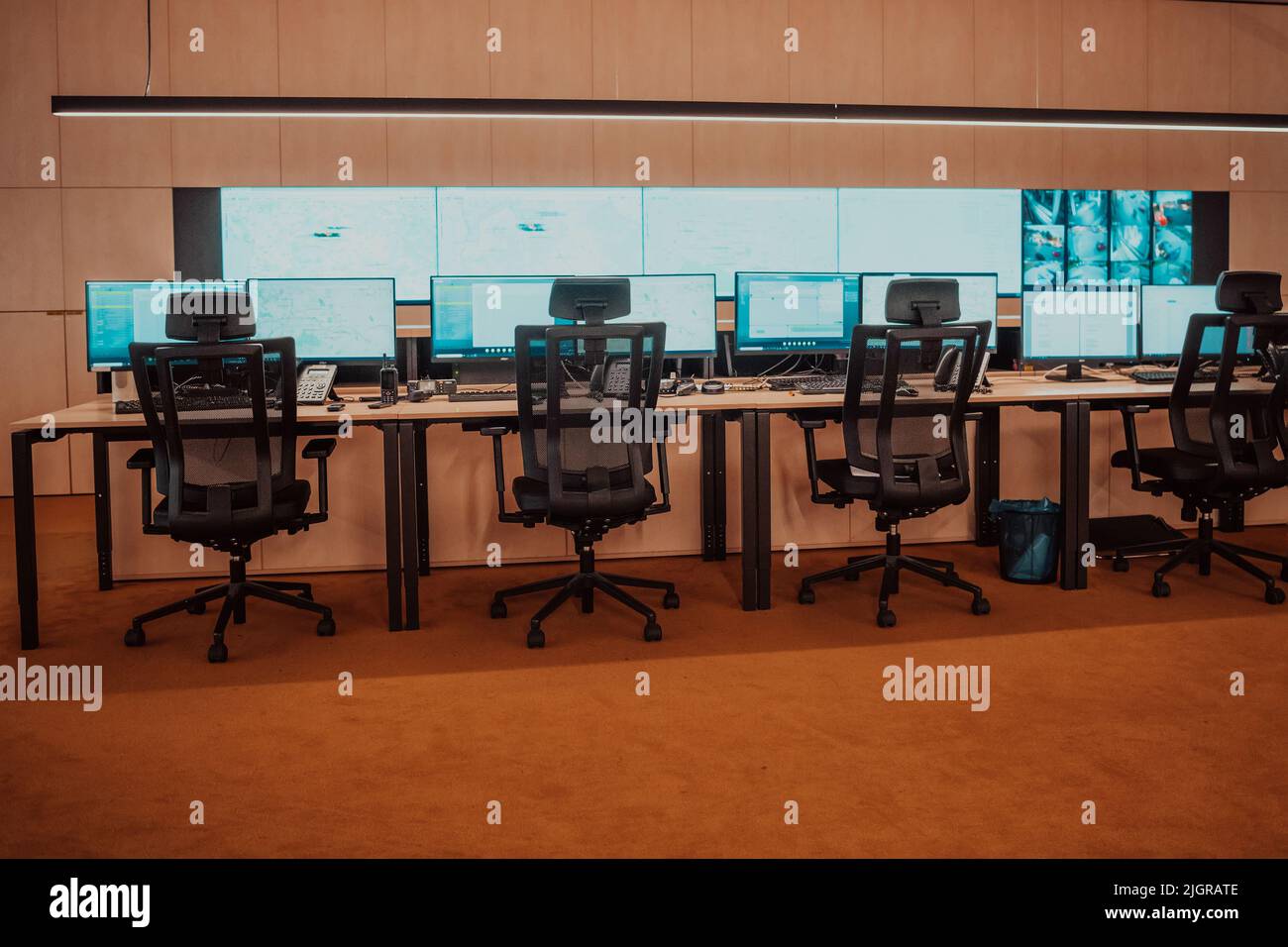 Empty interior of big modern security system control room, workstation ...
