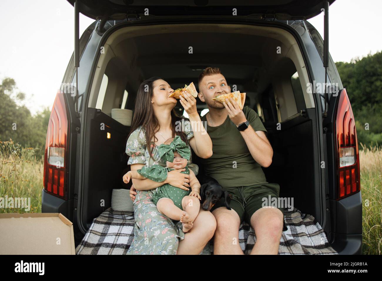 Beautiful married couple with daughter looking at camera while sitting ...