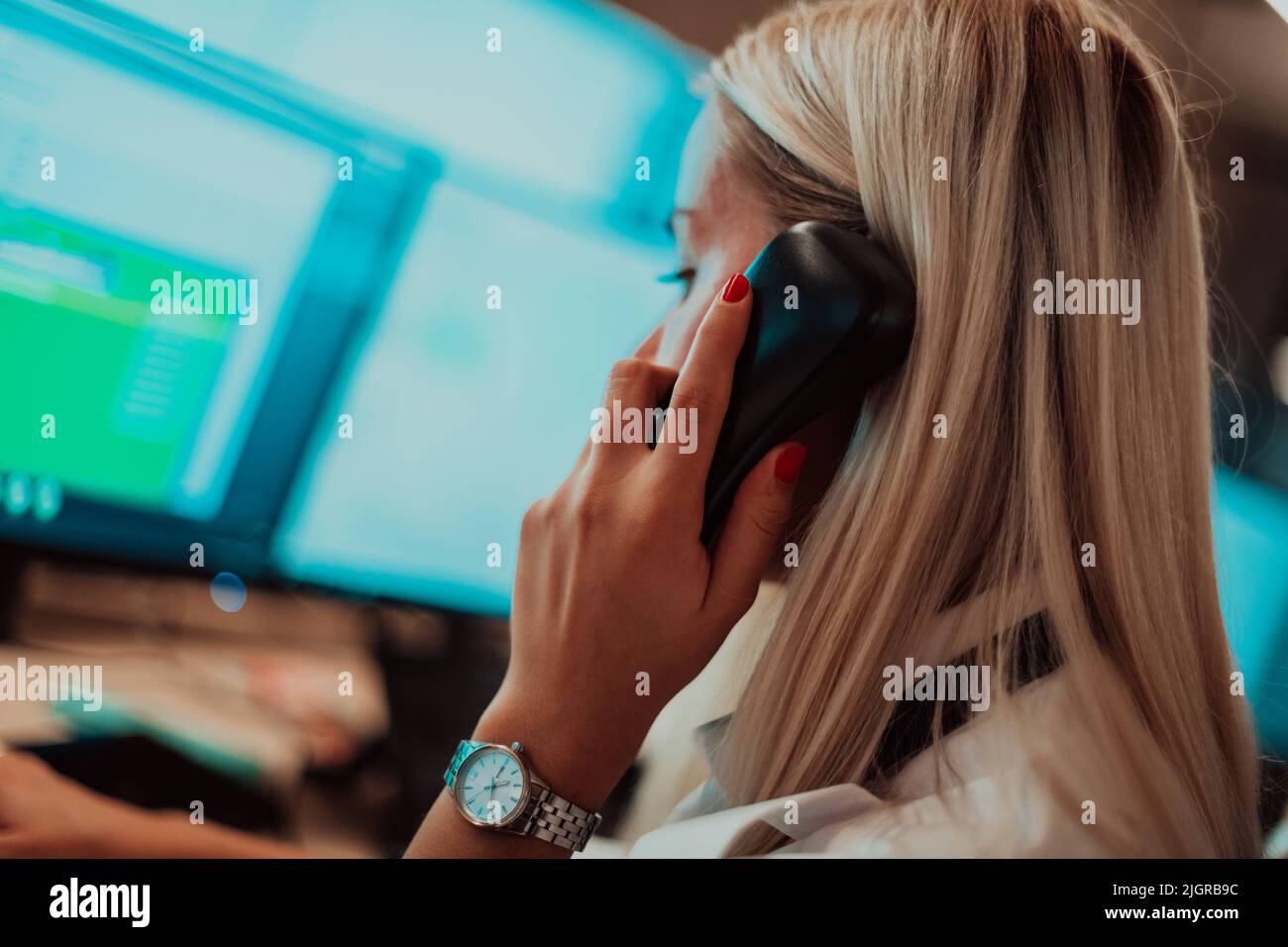 Female security guard operator talking on the phone while working at ...
