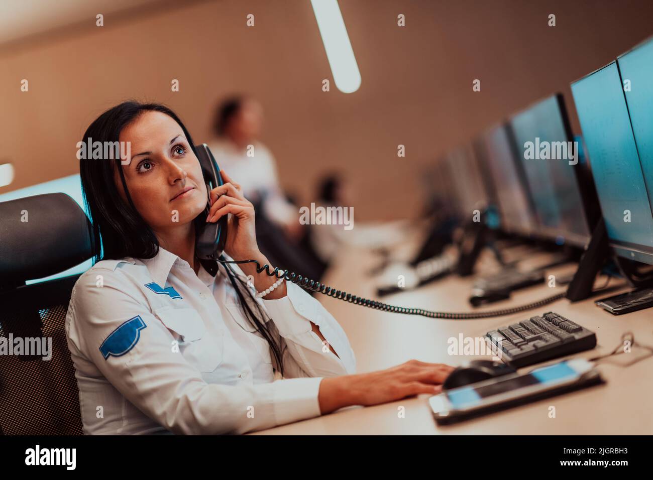 Female security guard operator talking on the phone while working at ...