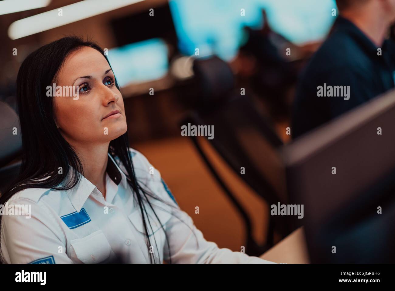 Female security operator working in a data system control room offices ...