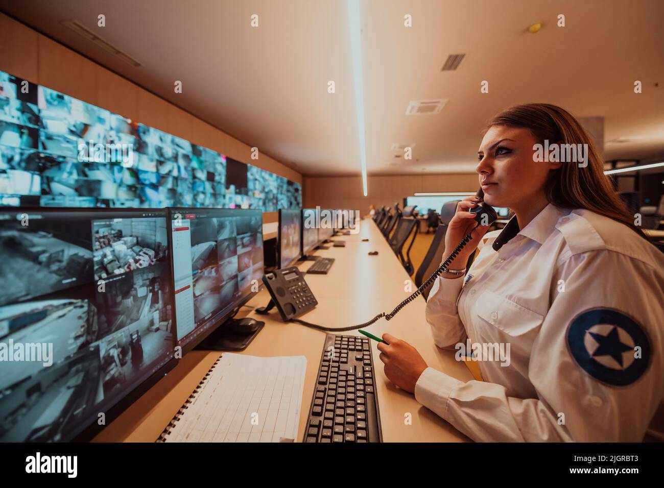 Female security guard operator talking on the phone while working at ...