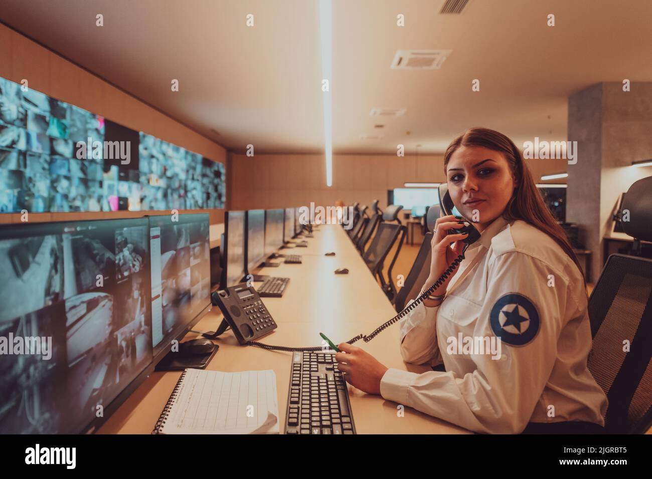 Female security guard operator talking on the phone while working at ...