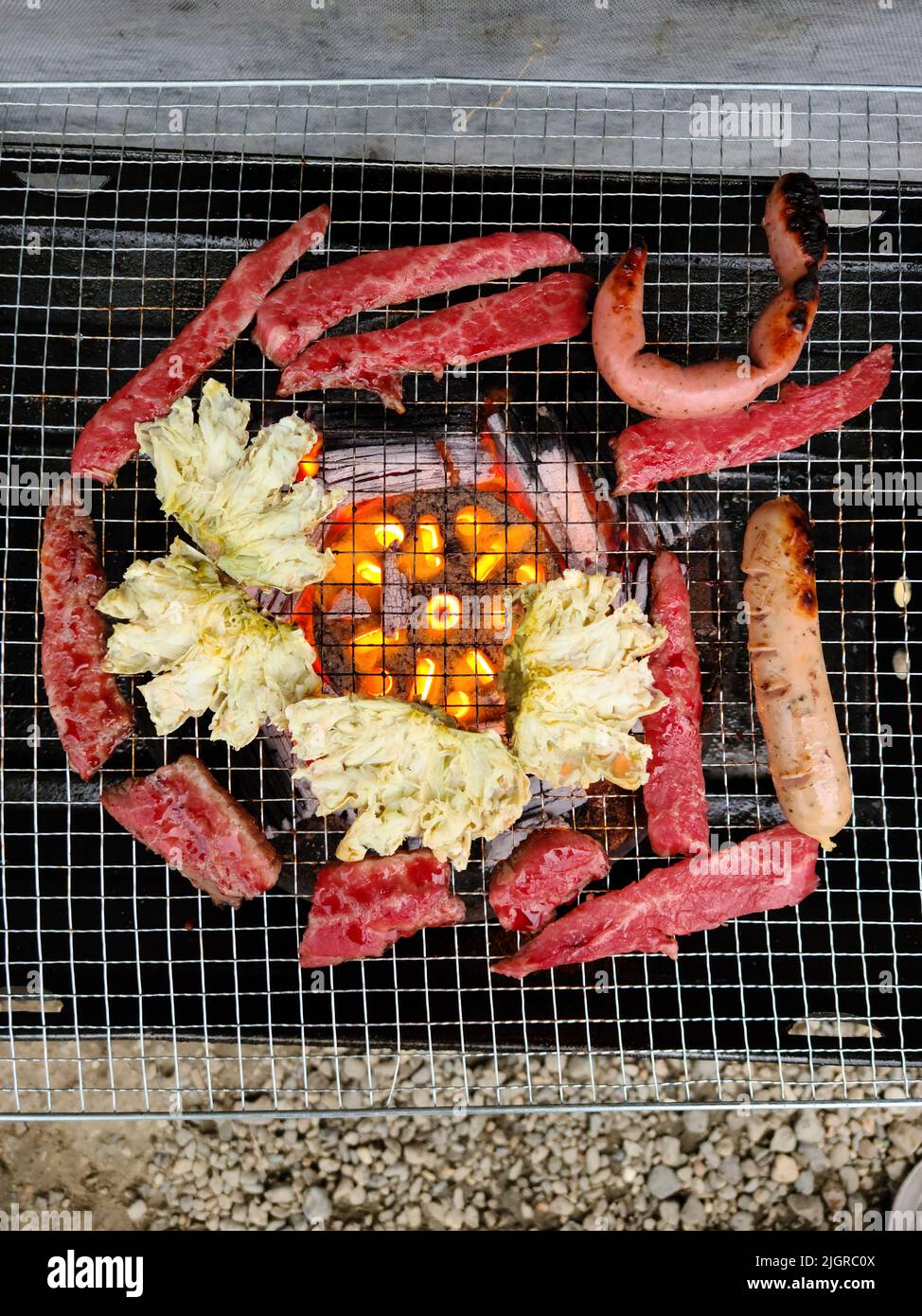 A sausage and beef bacon on a grilling screen Stock Photo - Alamy