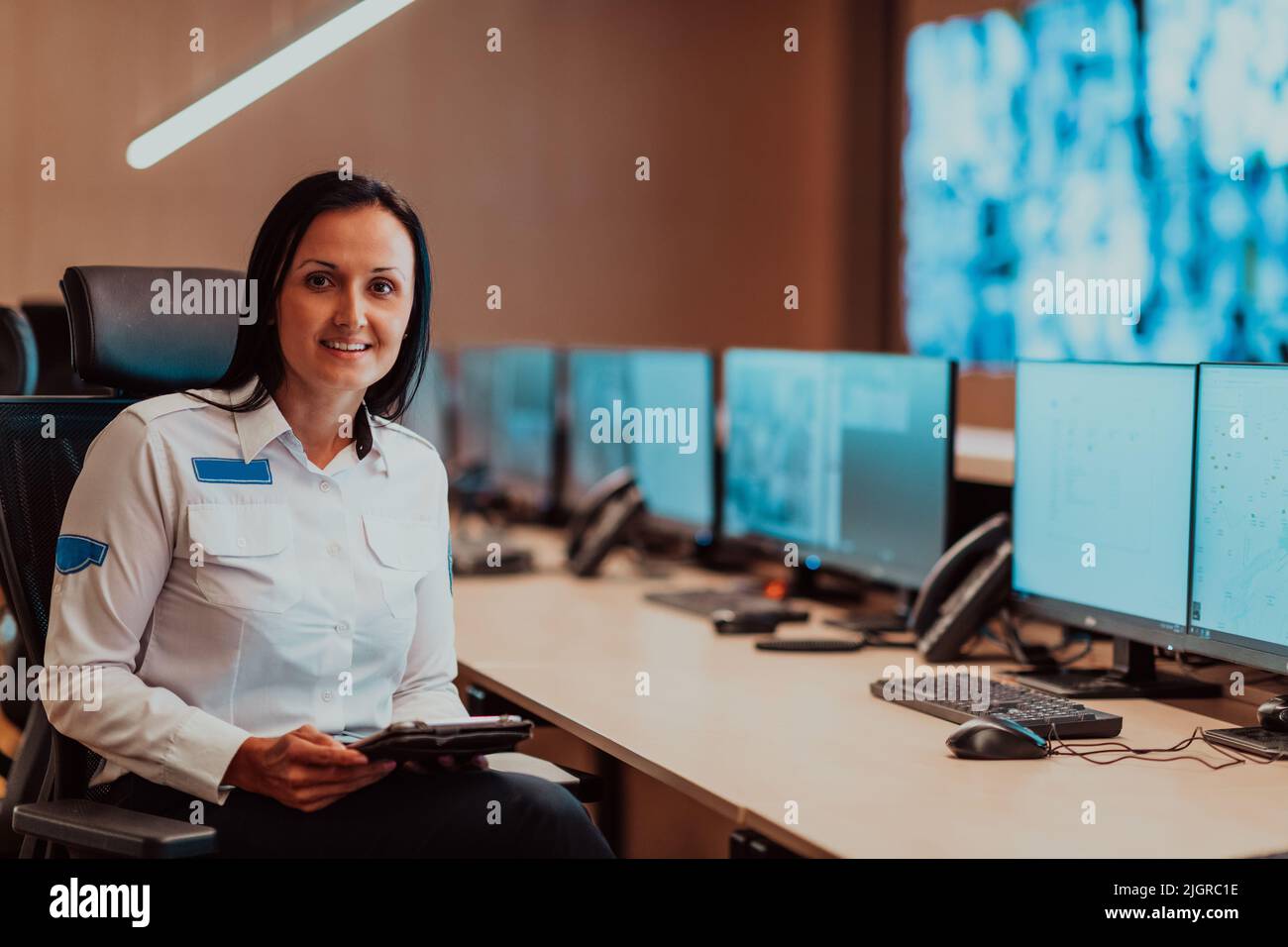 Female security operator working in a data system control room offices ...