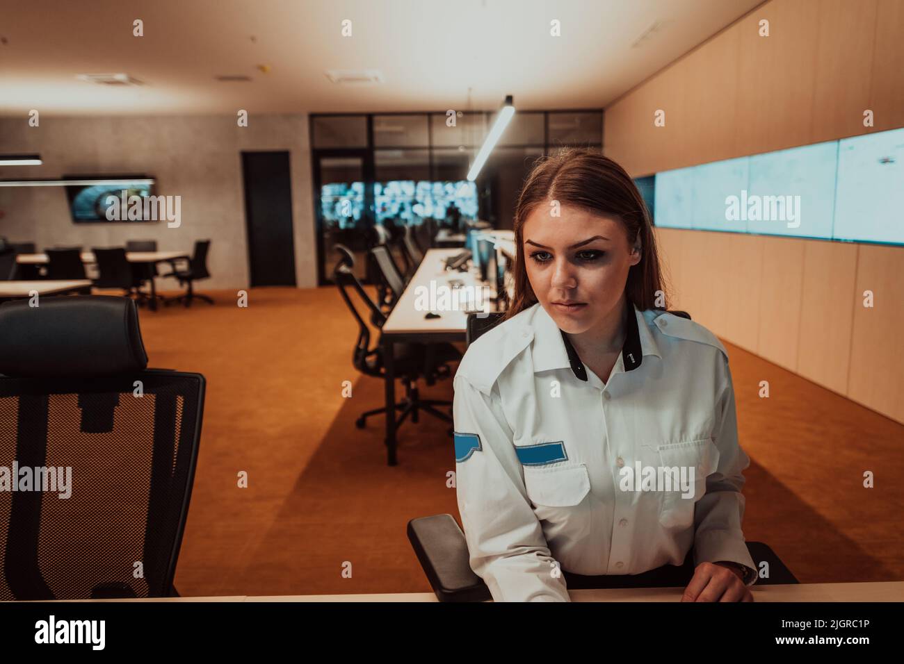 Female security operator working in a data system control room offices ...