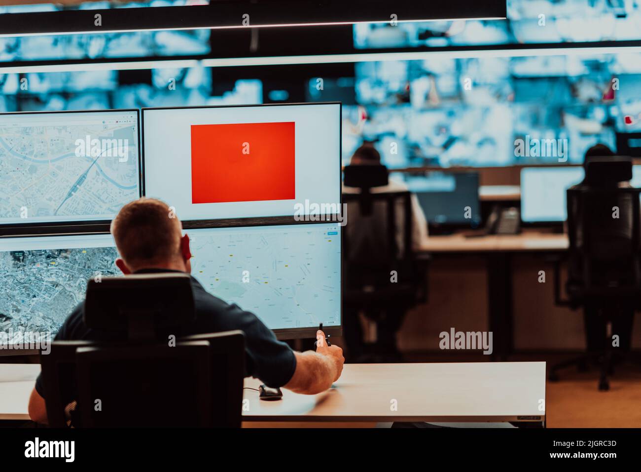 Male security operator working in a data system control room offices ...