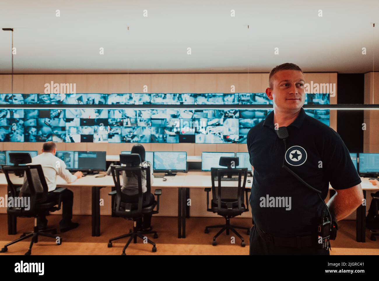 Male security operator working in a data system control room offices ...