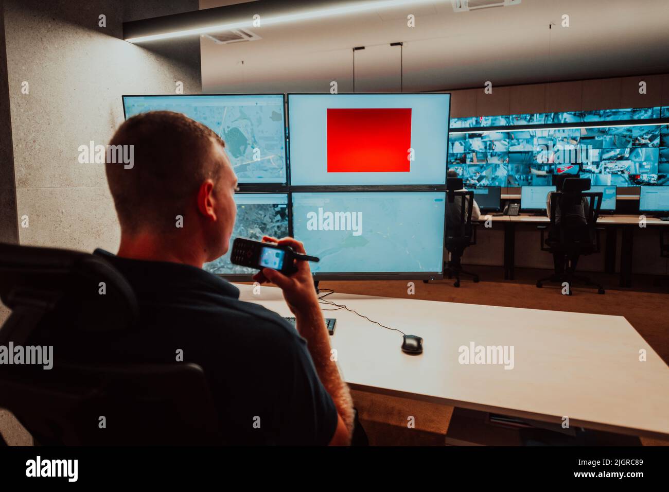 Male security operator working in a data system control room offices ...