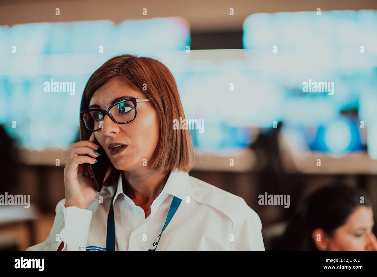 Female security guard operator talking on the phone while working at ...