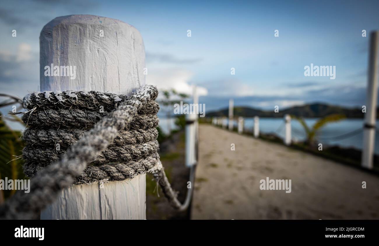 A close up of rope on a wooden railing of a pier Stock Photo - Alamy