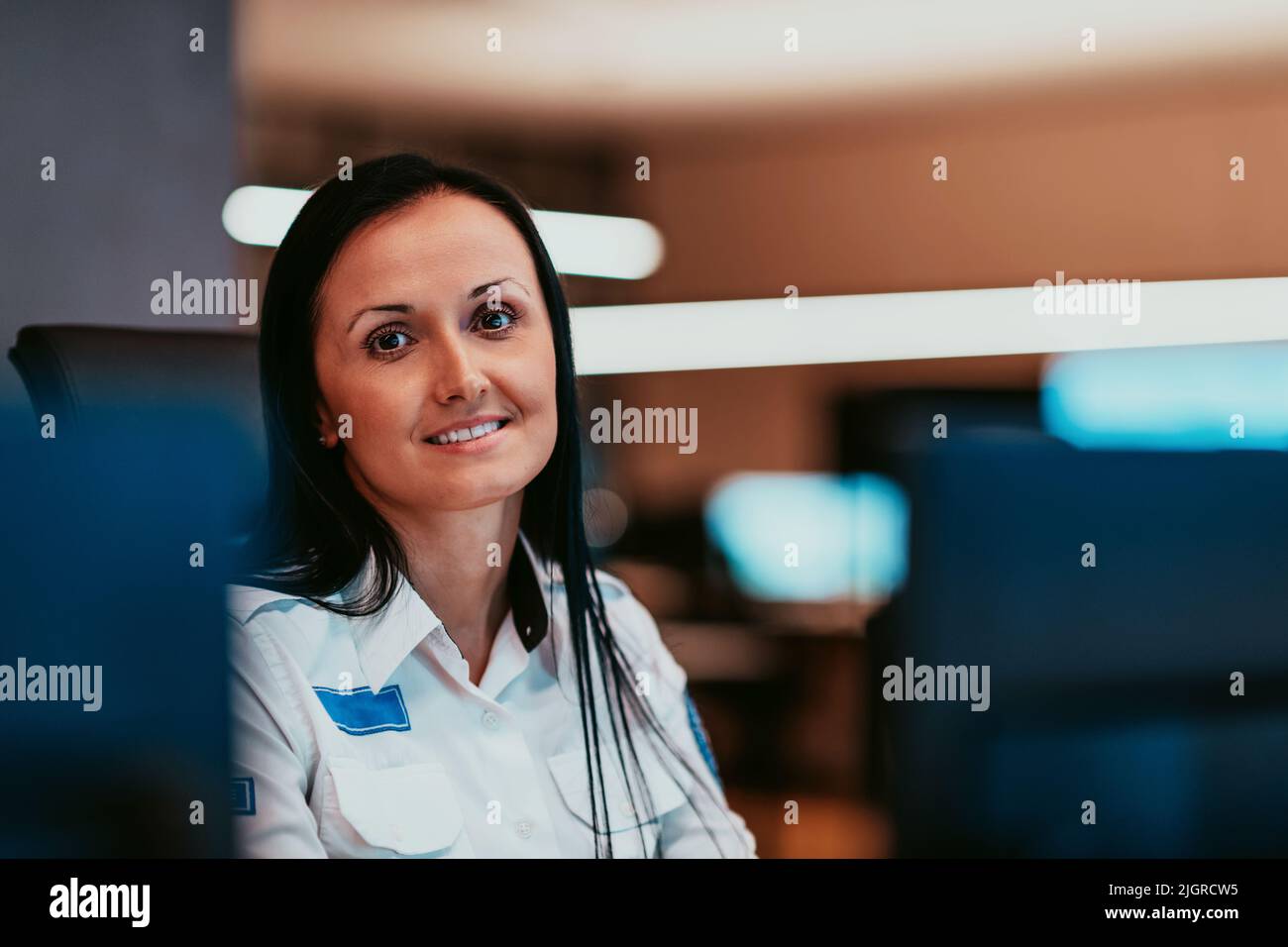 Female security operator working in a data system control room offices ...