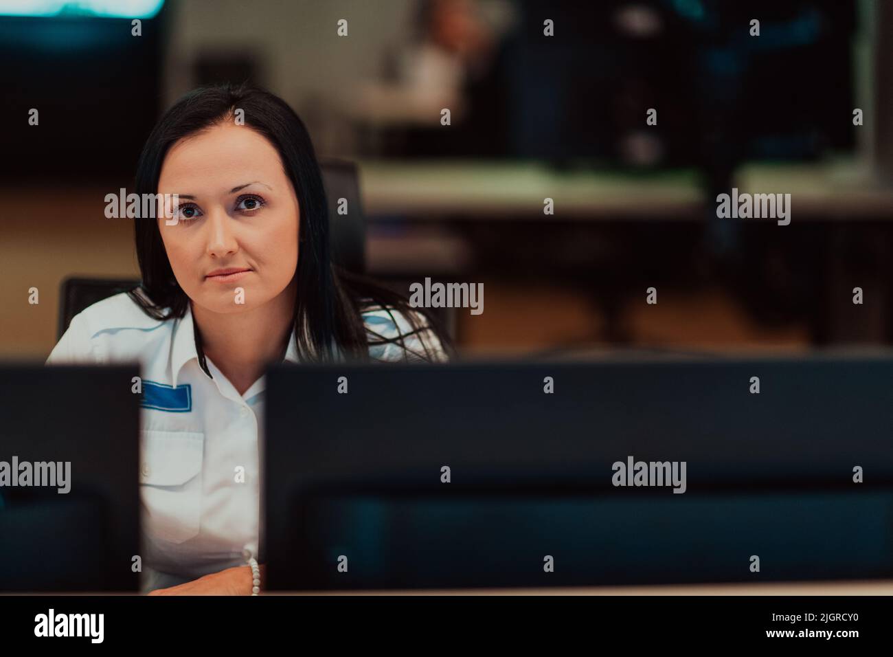 Female security operator working in a data system control room offices ...