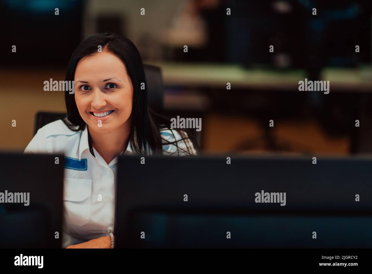 Female security operator working in a data system control room offices ...