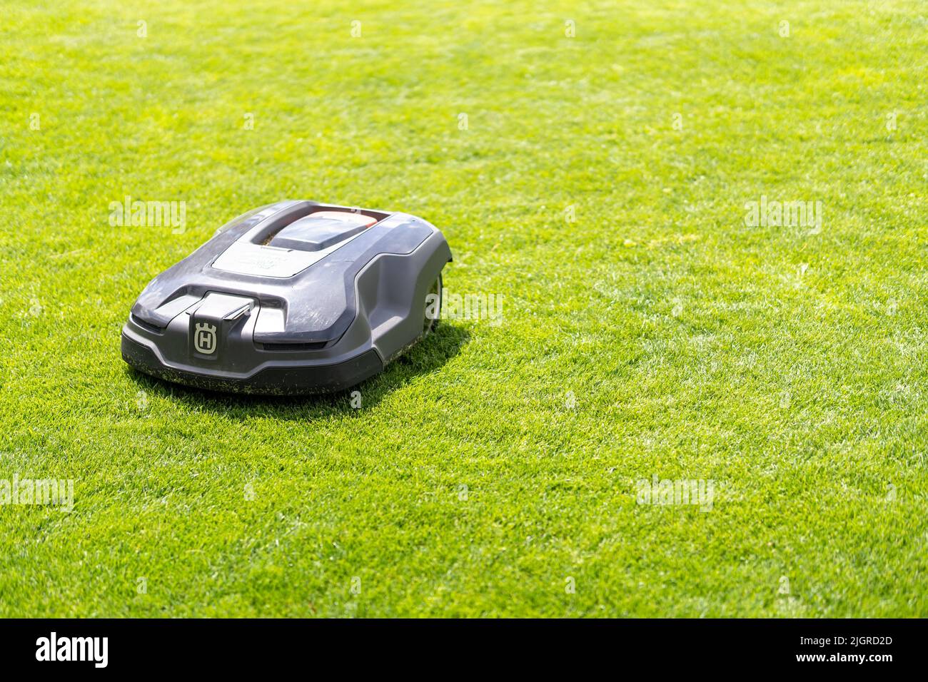 The automatic grass cutting machine in a garden - robot lawn mower on ... The automatic grass cutting machine in a garden - robot lawn mower on ...