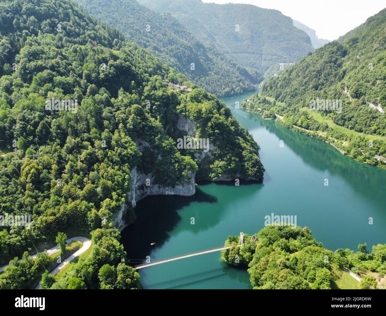 A high angle shot of the lake Corlo in a valley surrounded by hills ...