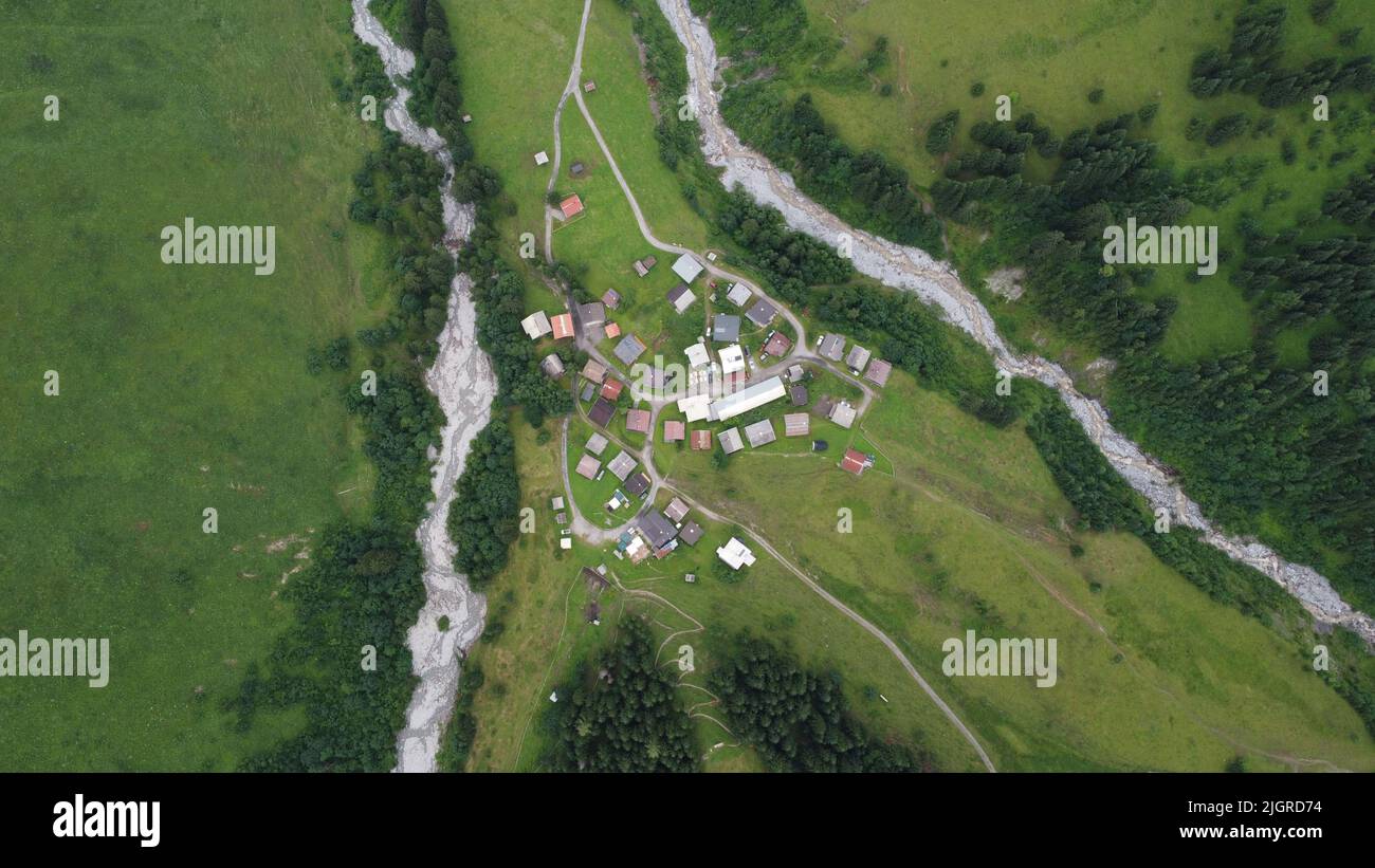 The small rural buildings surrounded by lush greenery from a bird's eye ...