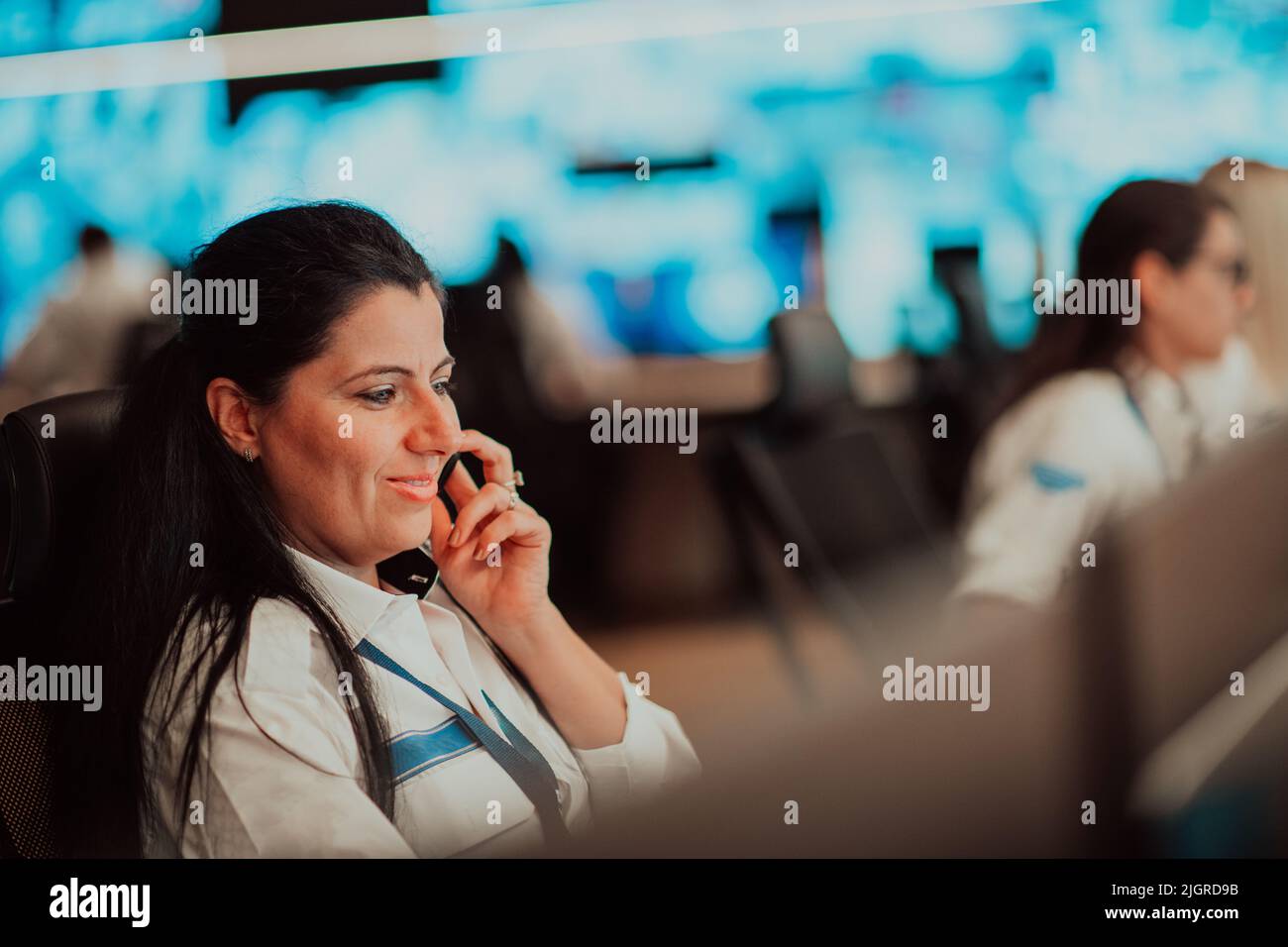 Female security guard operator talking on the phone while working at ...