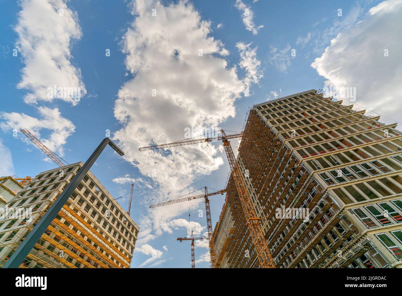A bottom view of the construction cranes near buildings under ...